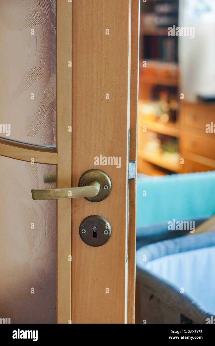 Vertical shot of a wooden door with a metal handler with the shelves in ...