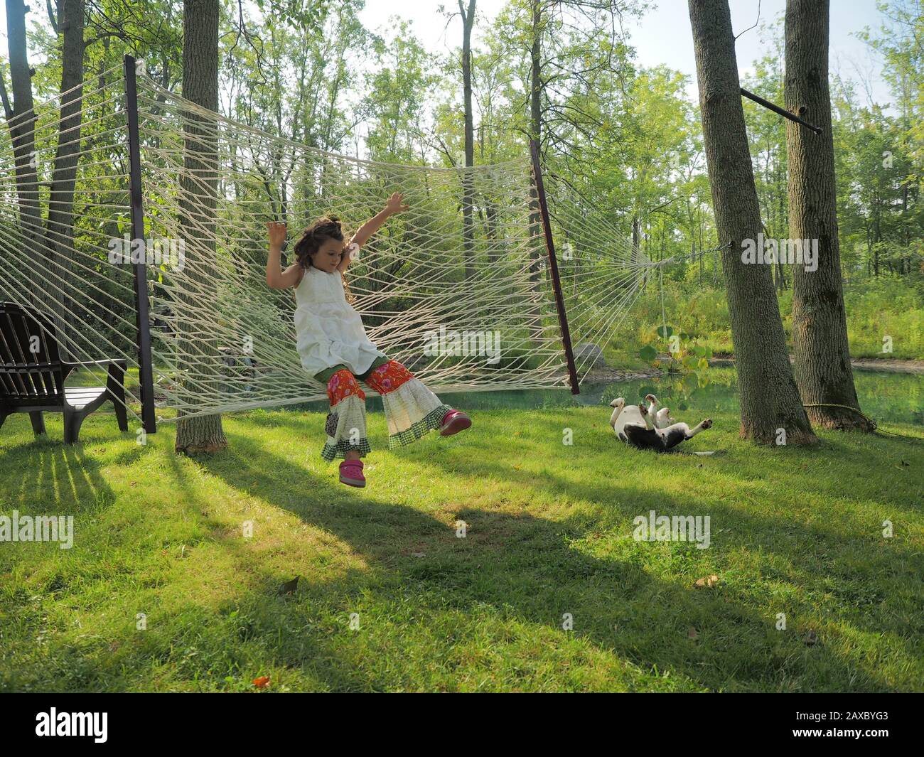 Cute little girl having fun on a hammock in the garden Stock Photo - Alamy
