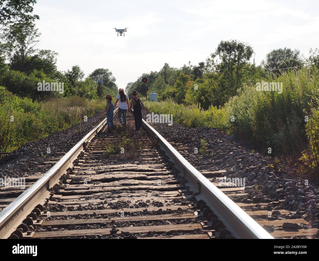 Three kids walking through the train rails in the countryside Stock ...