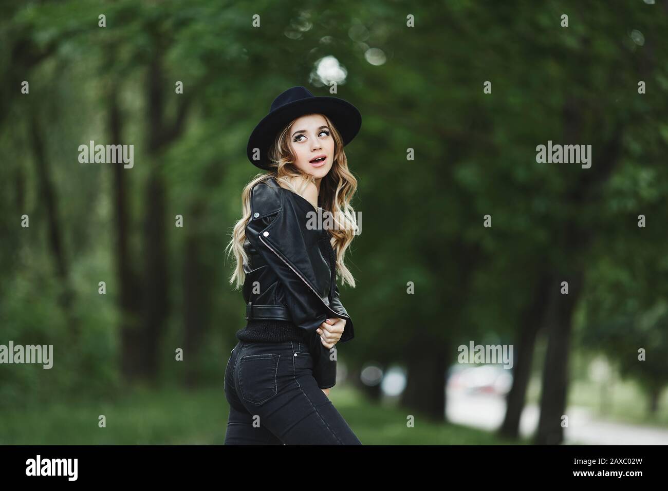 Portrait of excited model girl with trendy makeup in a black leather ...