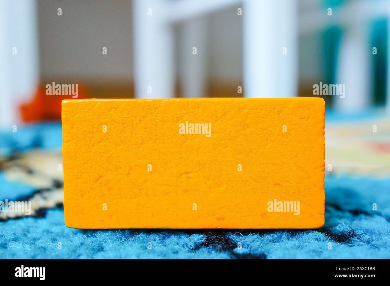 Orange rectangular toy for children put on a multicolored surface Stock ...