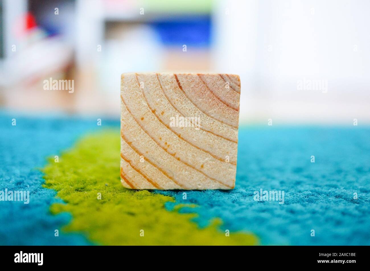 Striped square toy on a blue and green surface Stock Photo - Alamy