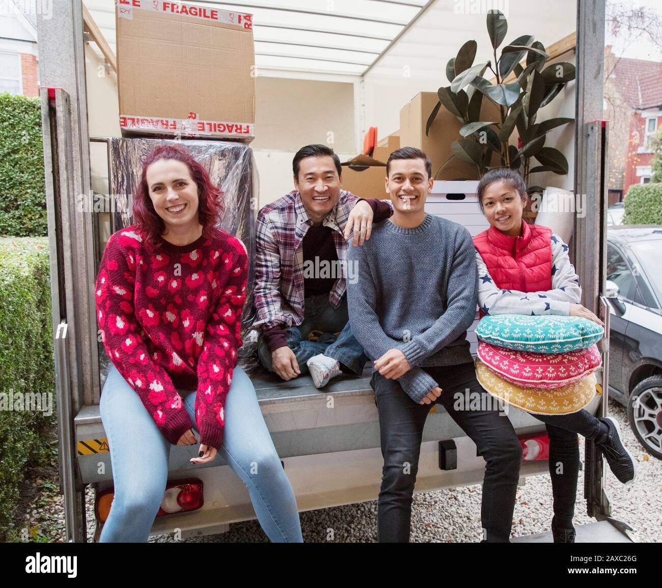 Portrait happy friends at back of moving van Stock Photo - Alamy