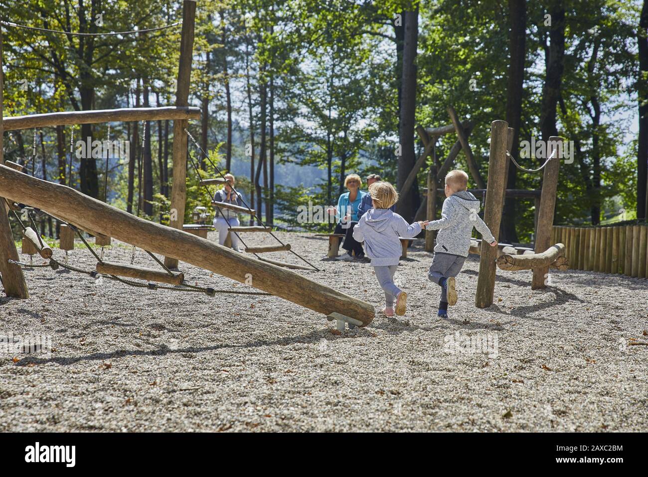 Happy kids playing in the playground under the supervision of parents ...