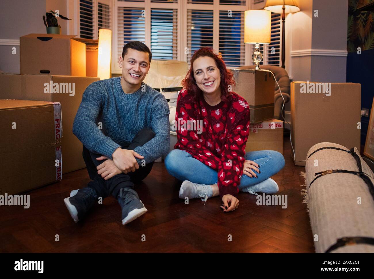 Portrait happy couple taking a break from moving Stock Photo - Alamy
