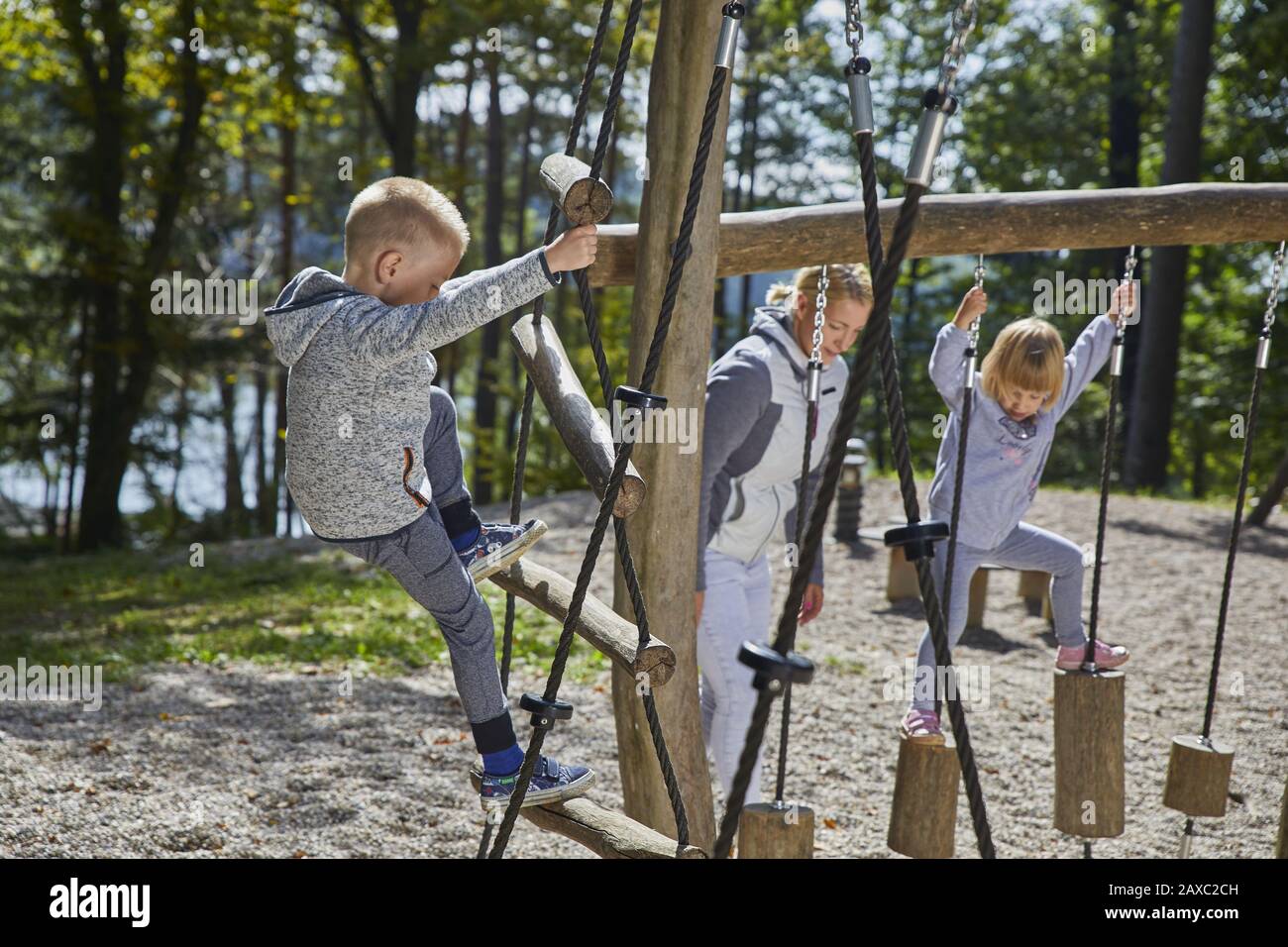 Happy kids playing in the playground under the supervision of parents ...