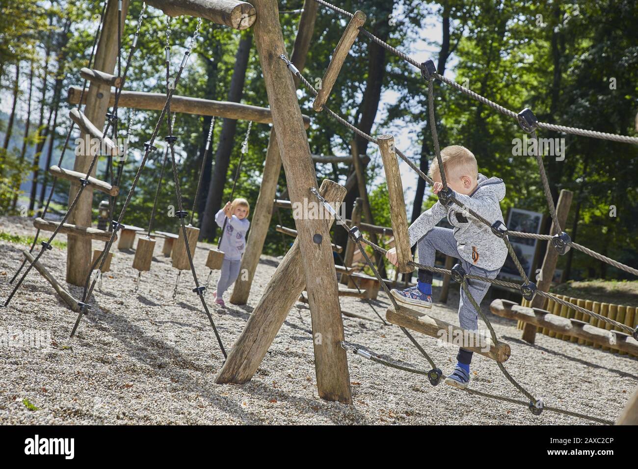 Happy kids playing in the playground under the supervision of parents ...