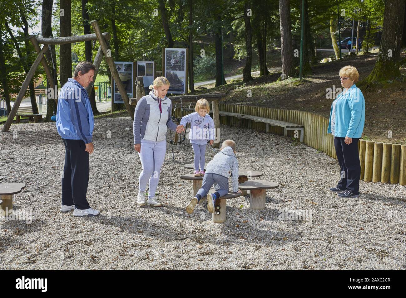 Happy kids playing in the playground under the supervision of parents ...
