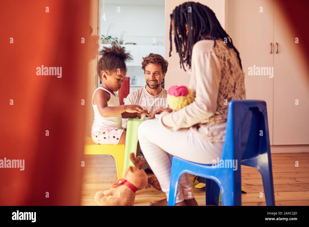 Young family enjoying imaginary tea party Stock Photo - Alamy