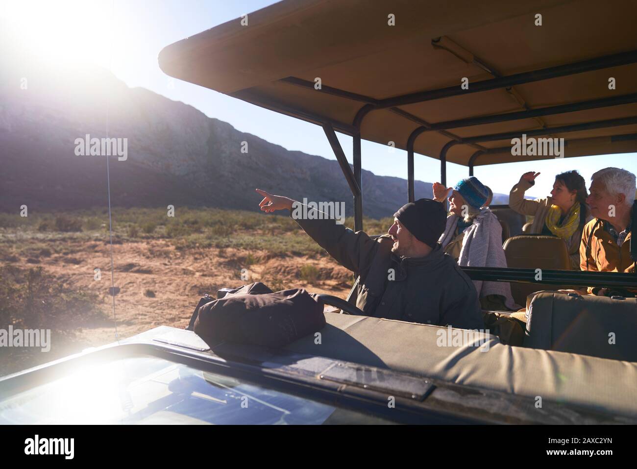 Safari tour guide and group in sunny off-road vehicle Stock Photo - Alamy