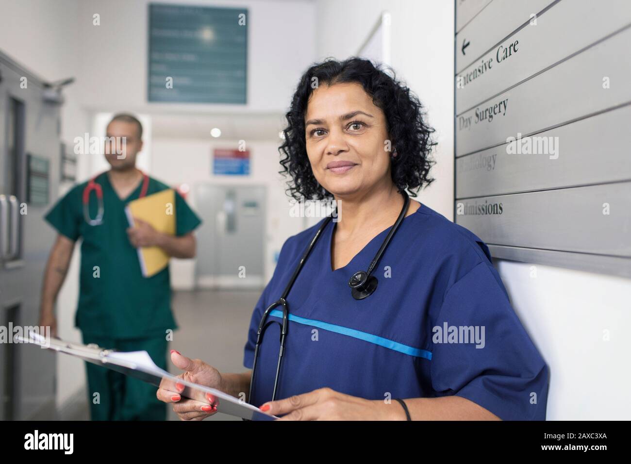 Portrait confident female doctor with medical chart, making rounds in ...