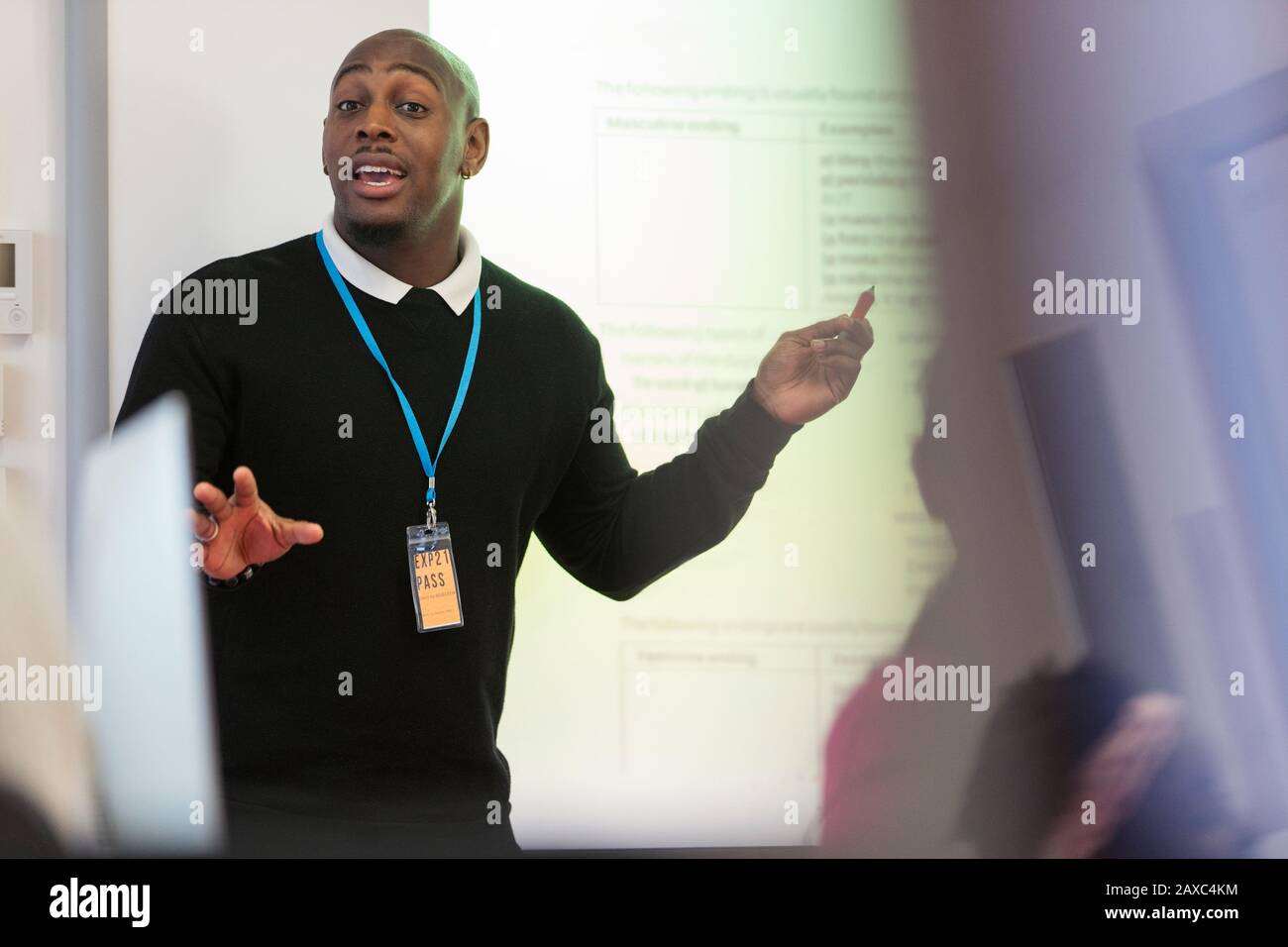 Male instructor leading lesson at projection screen in classroom Stock ...