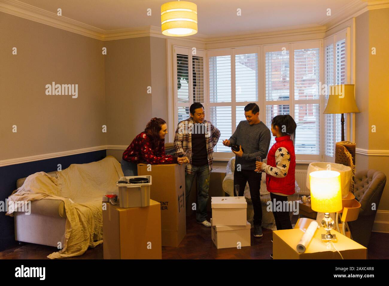 Friends taking a break from moving, celebrating with champagne Stock ...