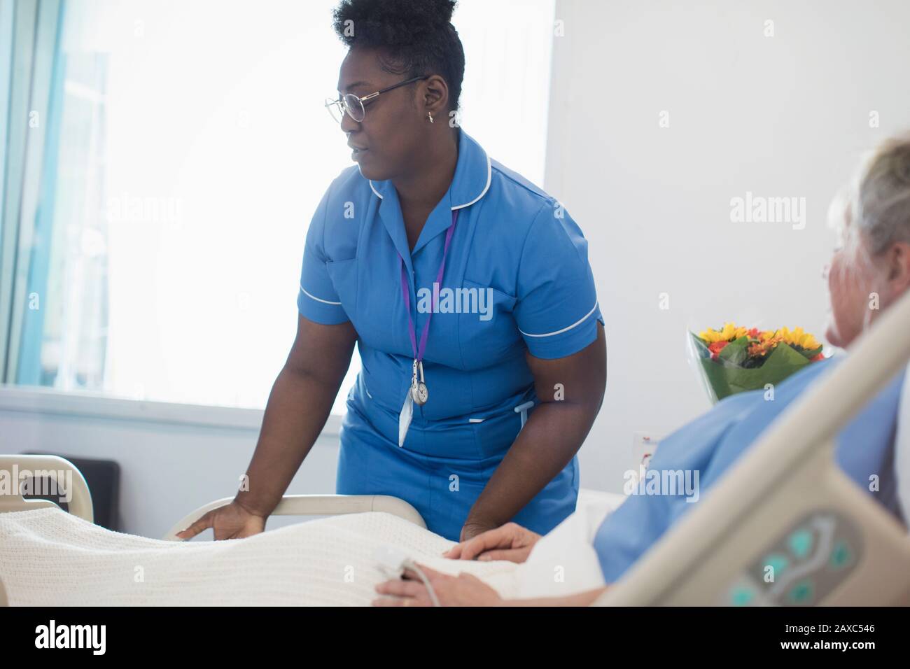 Female nurse helping patient in hospital bed Stock Photo - Alamy