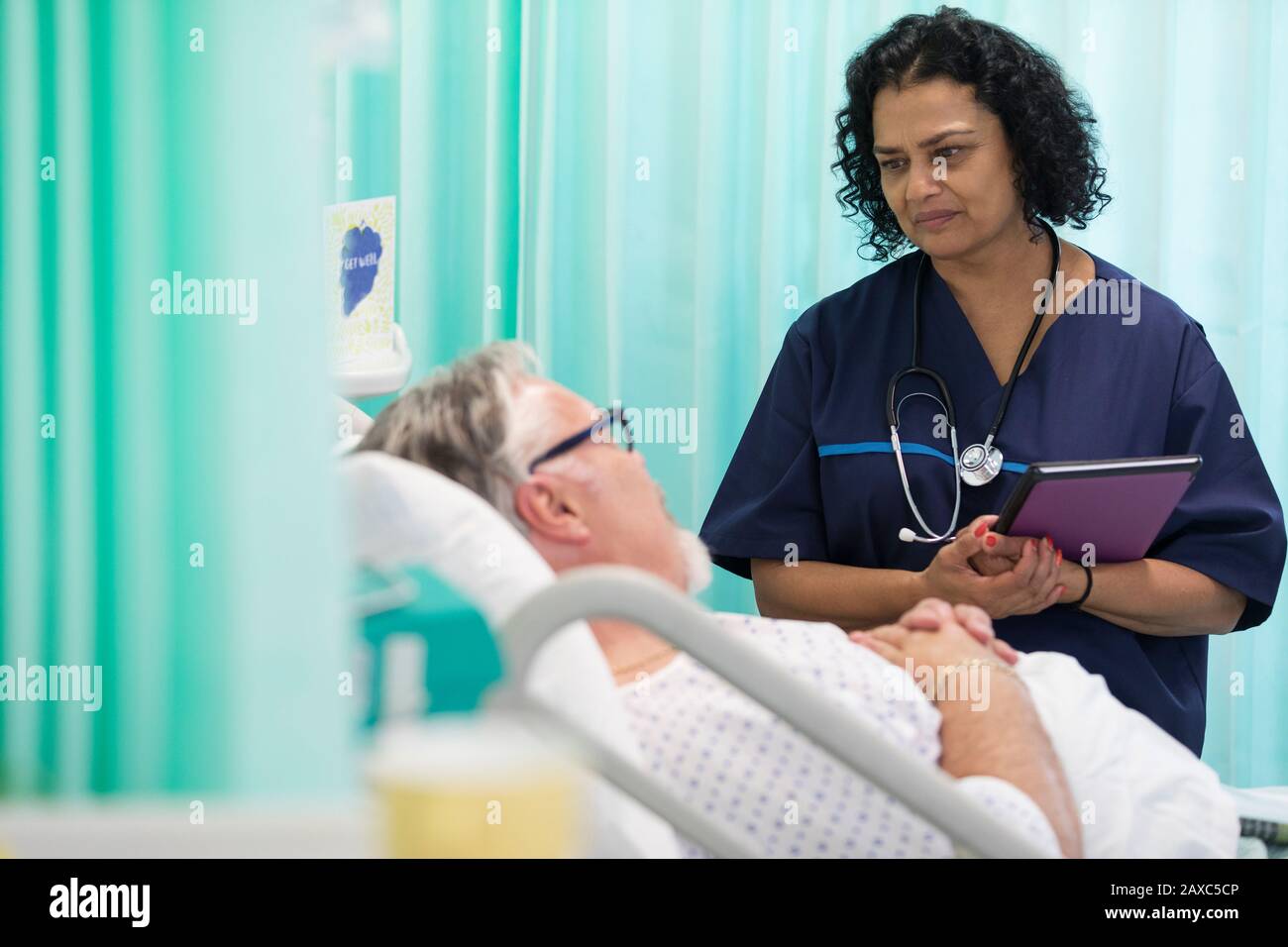 Doctor making rounds, talking with patient in hospital room Stock Photo ...