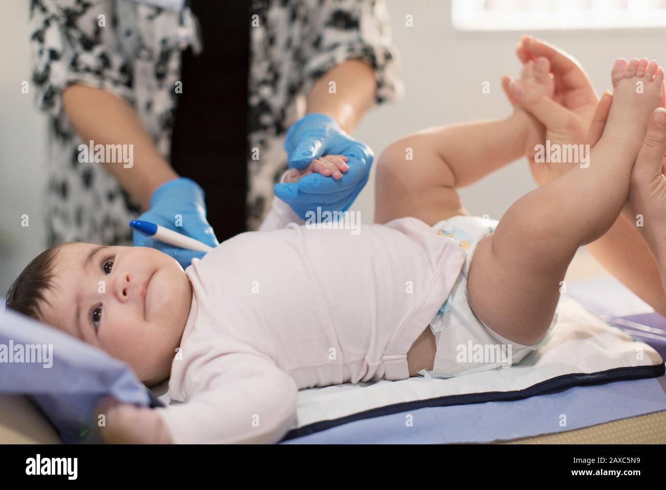 Cute baby girl laying examination room table Stock Photo - Alamy