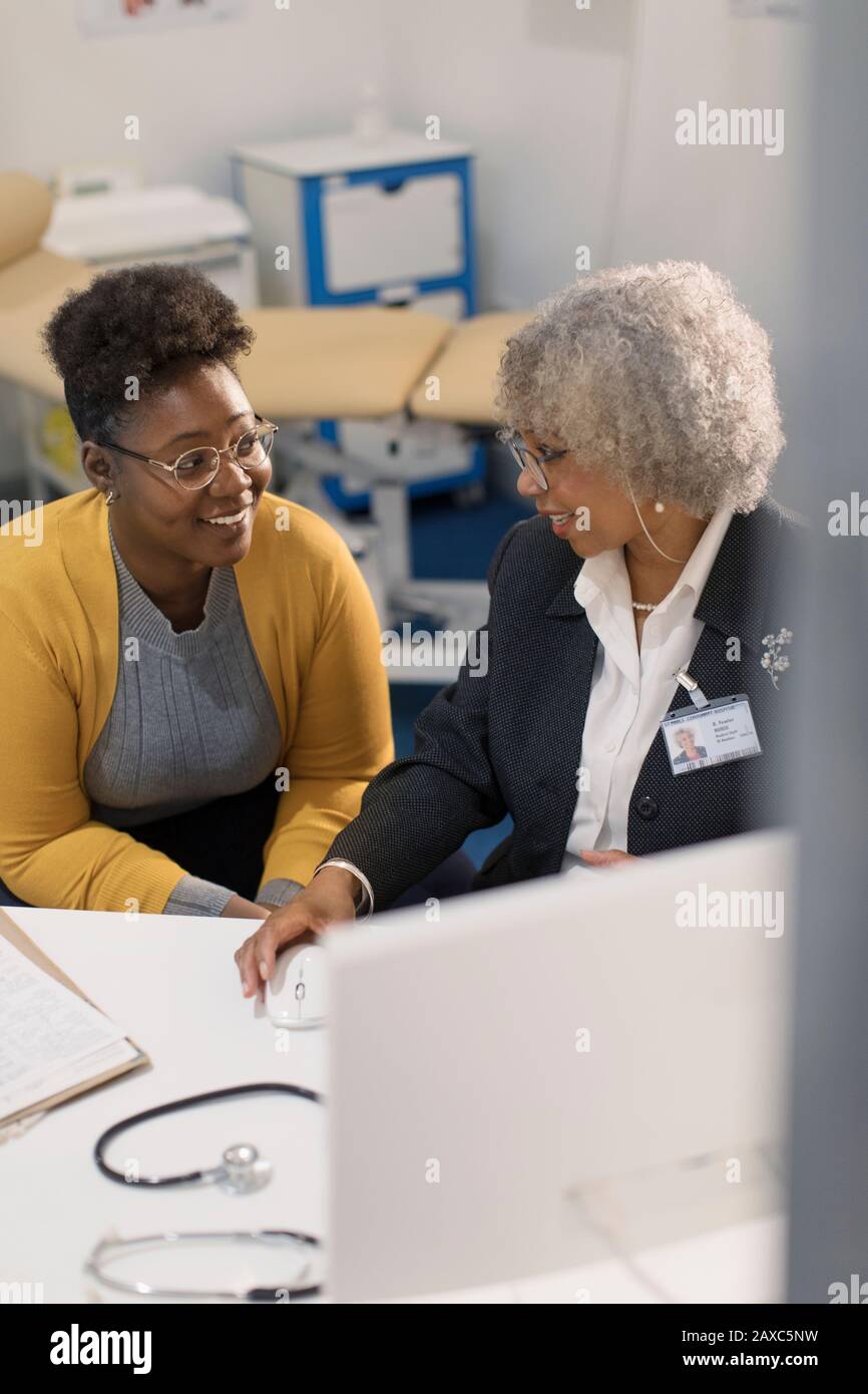 Female doctor meeting with patient at computer in doctors office Stock ...