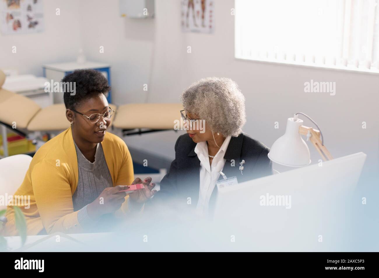 Female doctor prescribing medication to patient in doctors office Stock ...
