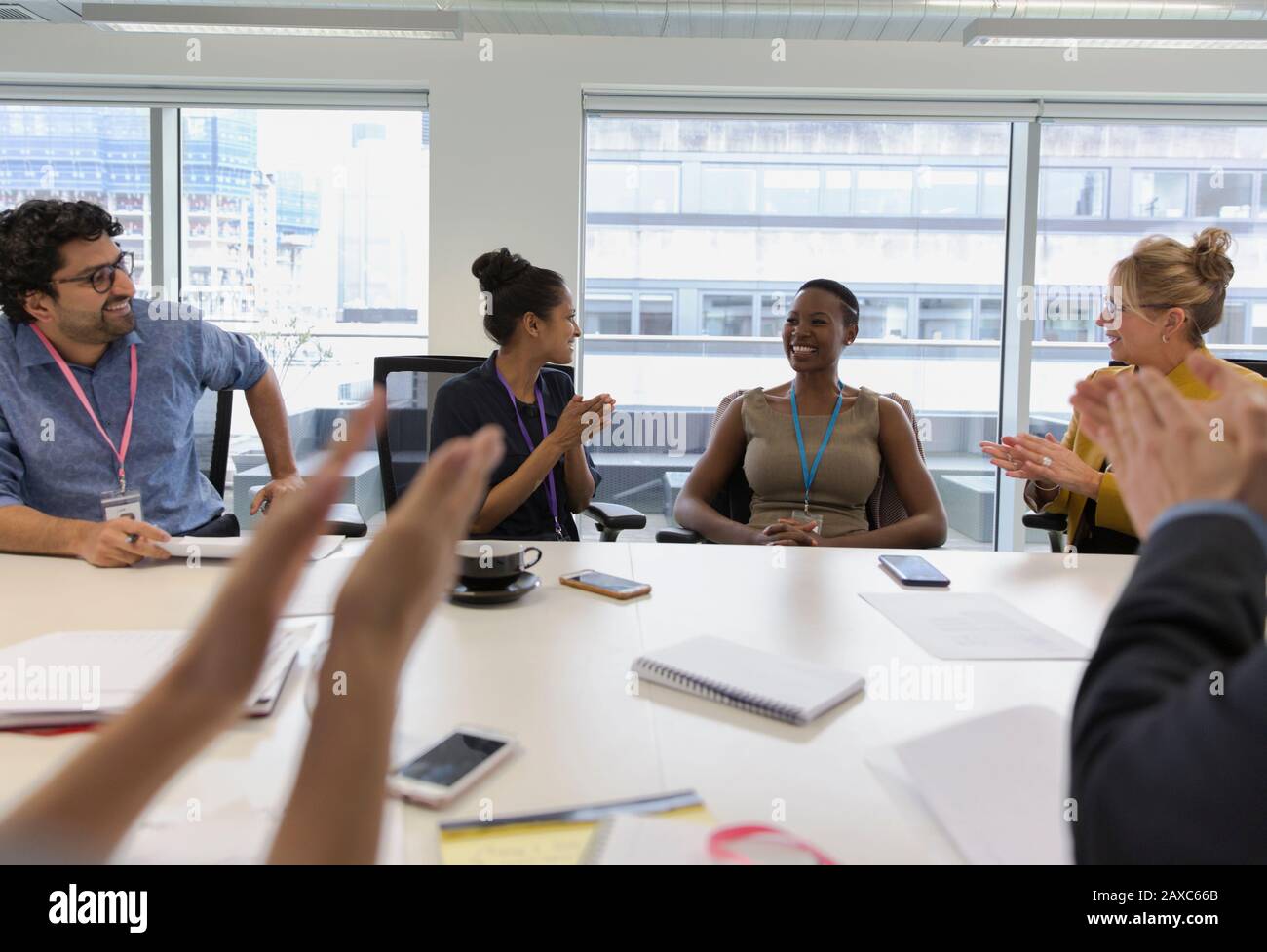 Happy business people clapping for colleague in conference room meeting ...