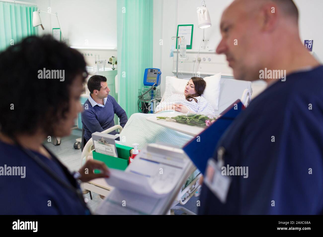 Doctors with medical chart making rounds with patient resting in ...