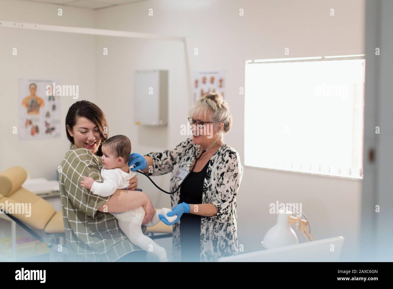 Female pediatrician examining baby girl in examination room Stock Photo ...