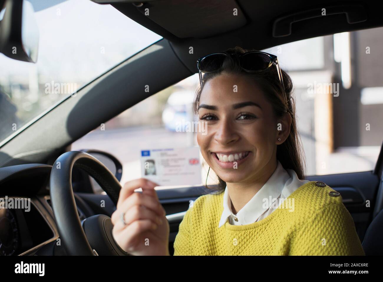Portrait happy young woman holding new drivers license in car Stock ...