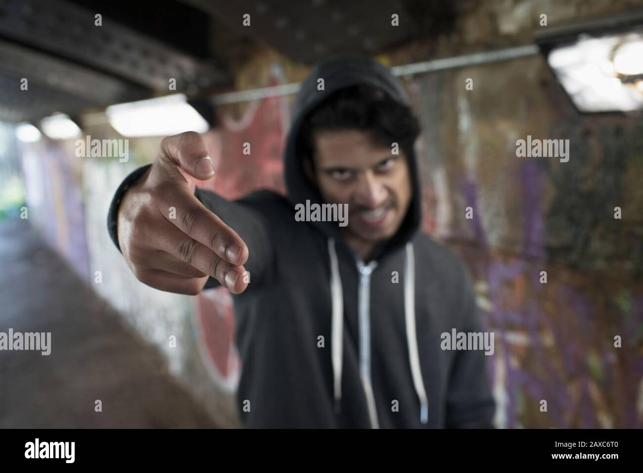 Portrait menacing young man gesturing finger gun in urban tunnel Stock ...