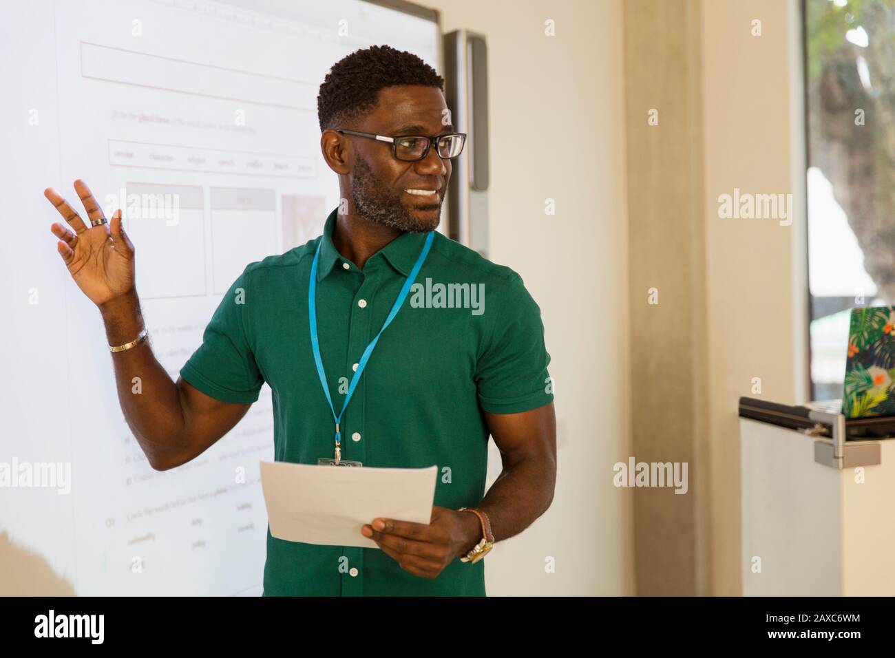 Male community college instructor at projection screen in classroom ...