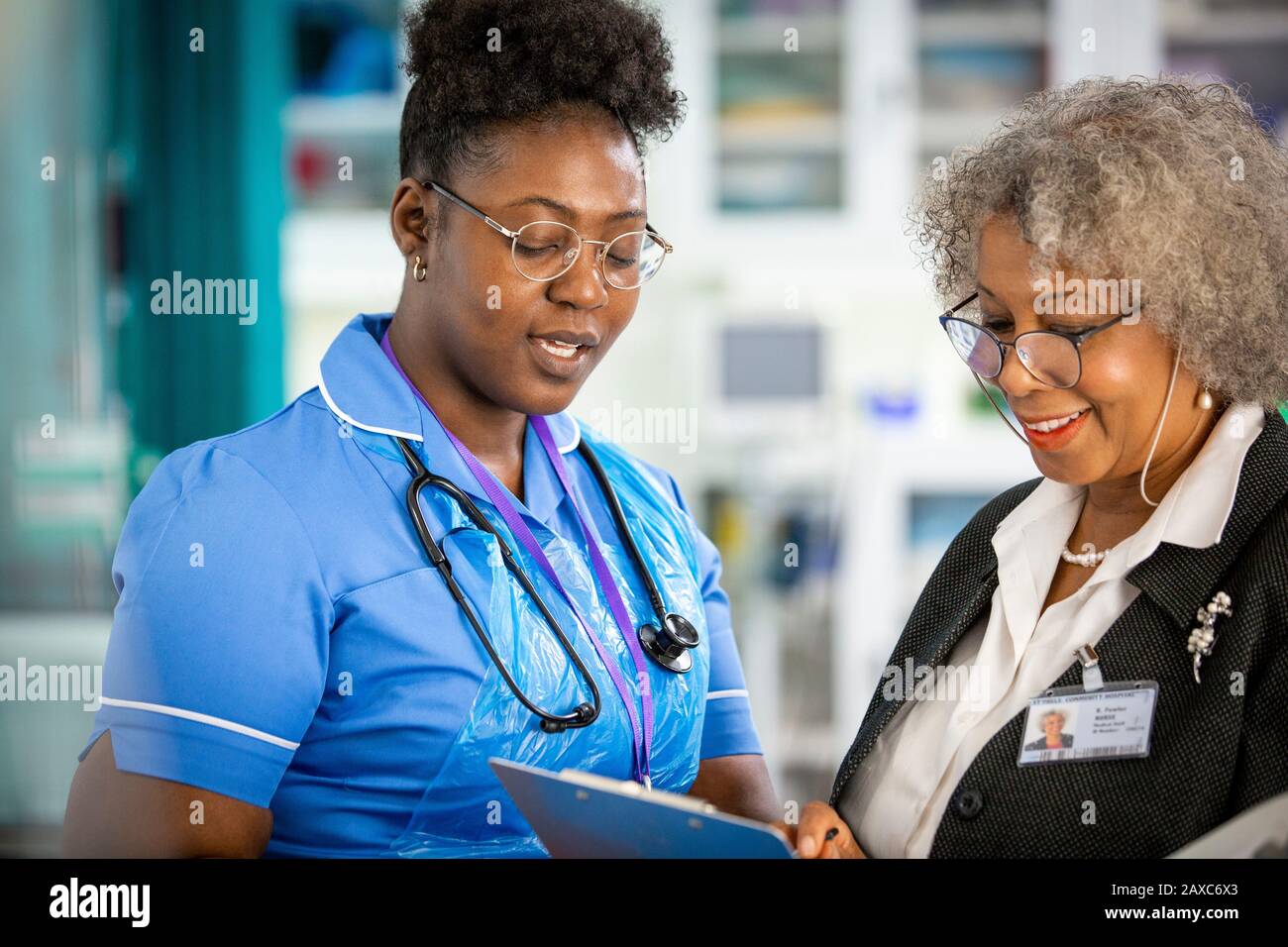 Female doctor and nurse talking Stock Photo - Alamy