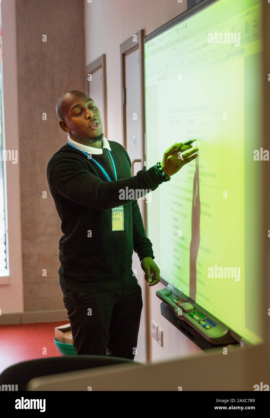 Male instructor leading lesson at projection screen in classroom Stock ...