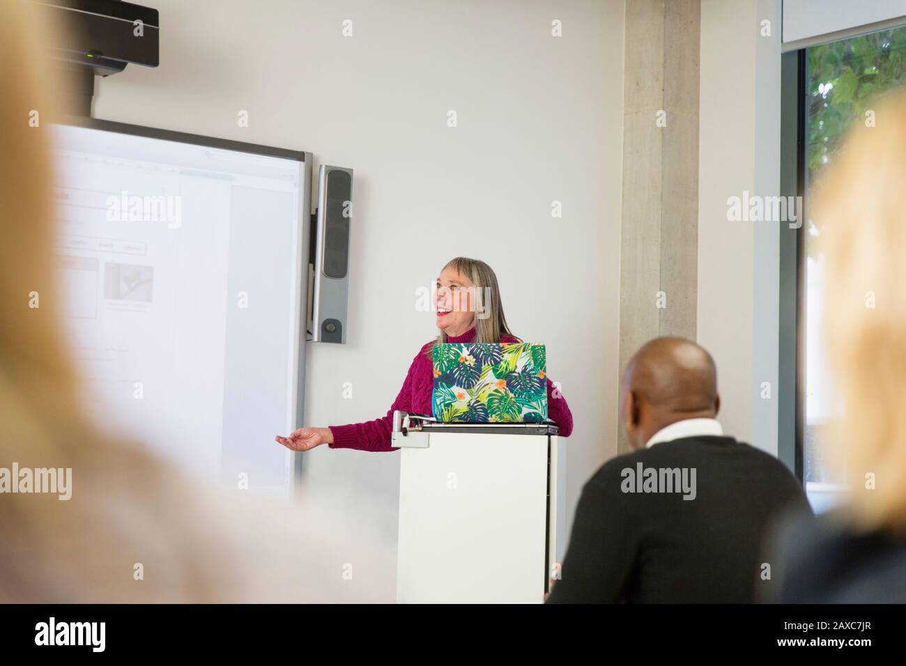 Female community college instructor leading lesson at laptop and ...