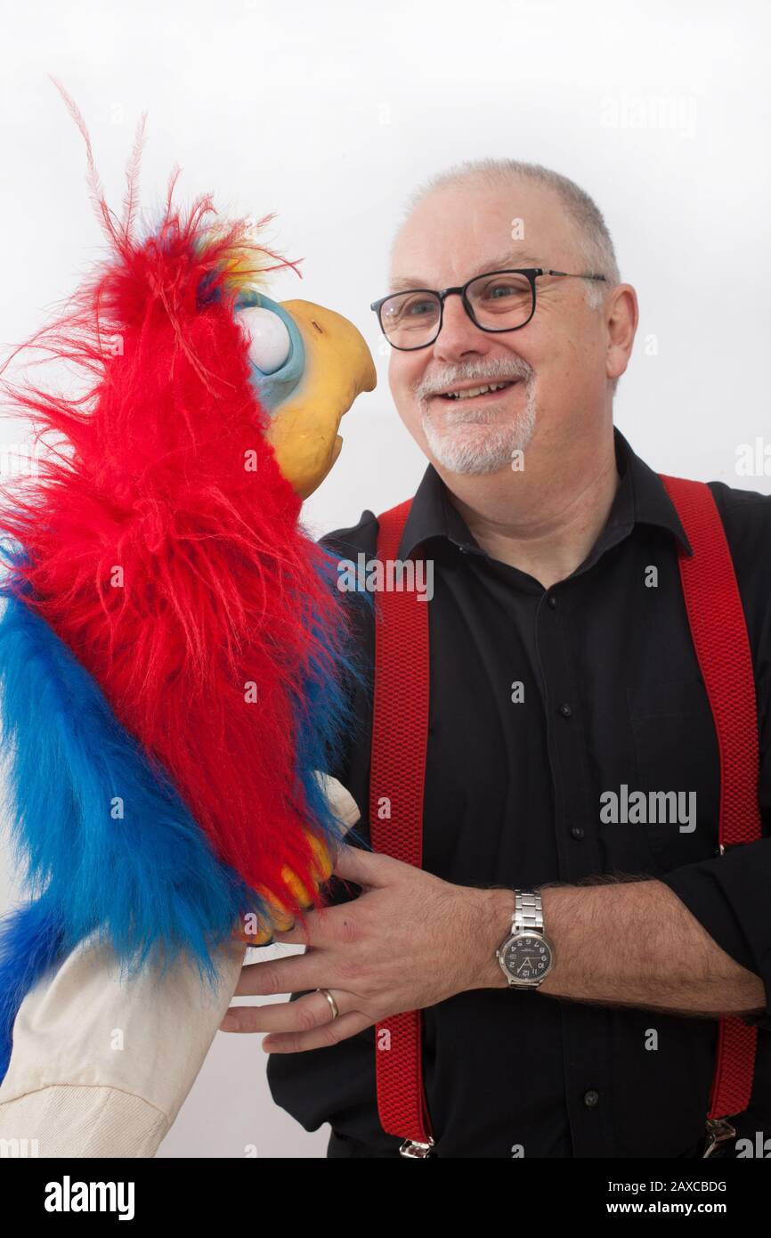 A ventriloquist with a parrot on his arm Stock Photo - Alamy