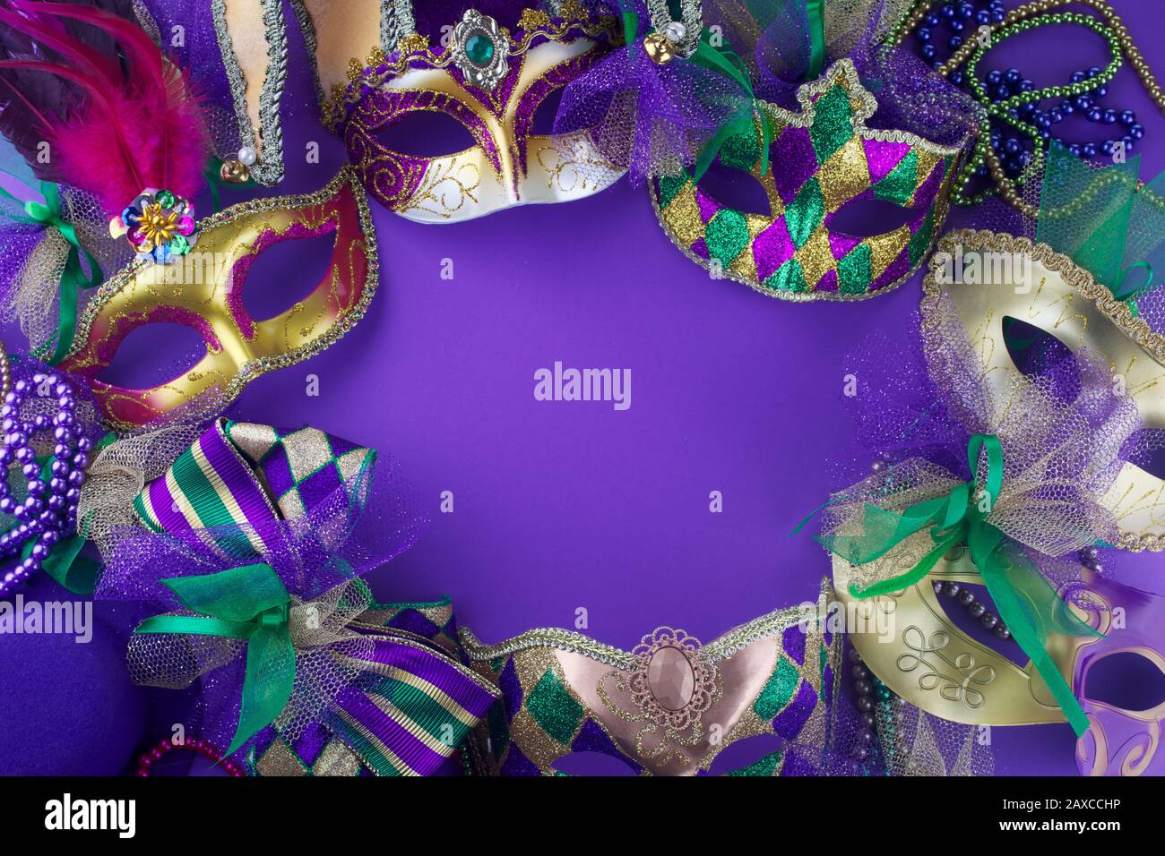 A group of Mardi Gras mask making a frame with copy space on a purple ...