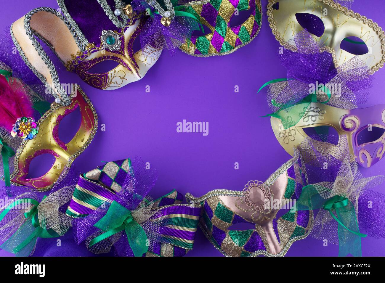 A group of Mardi Gras mask making a frame with copy space on a purple ...