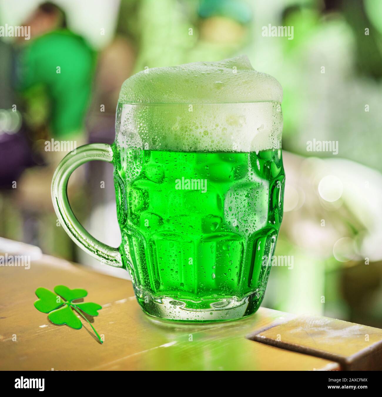 Glass of green beer stands on a table in a pub during the celebration ...
