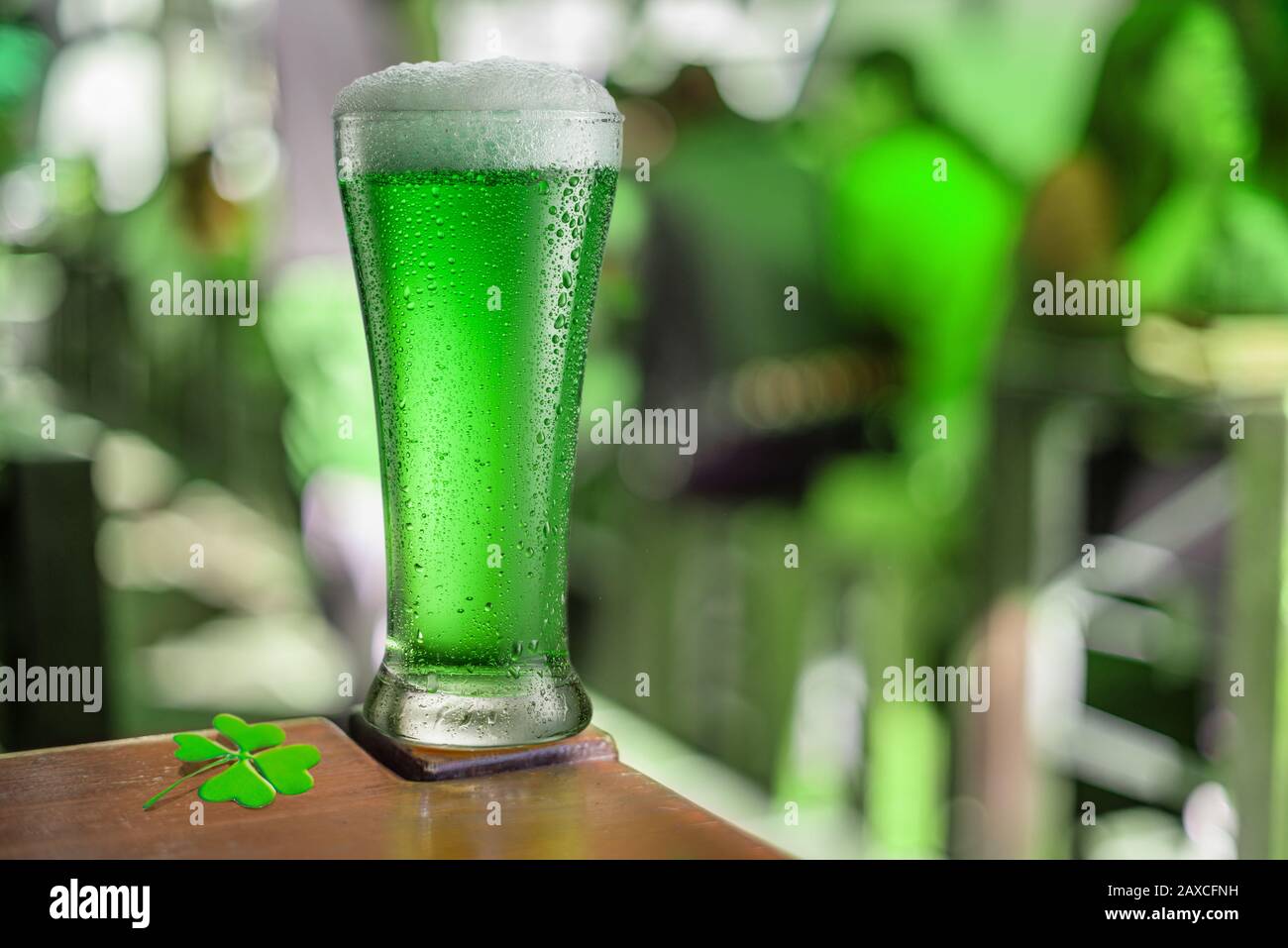 Glass of green beer stands on a table in a pub during the celebration ...