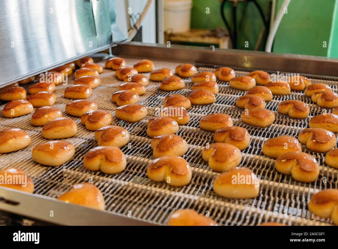 Baking production line. Cookies in form of hearts after glaze coating ...