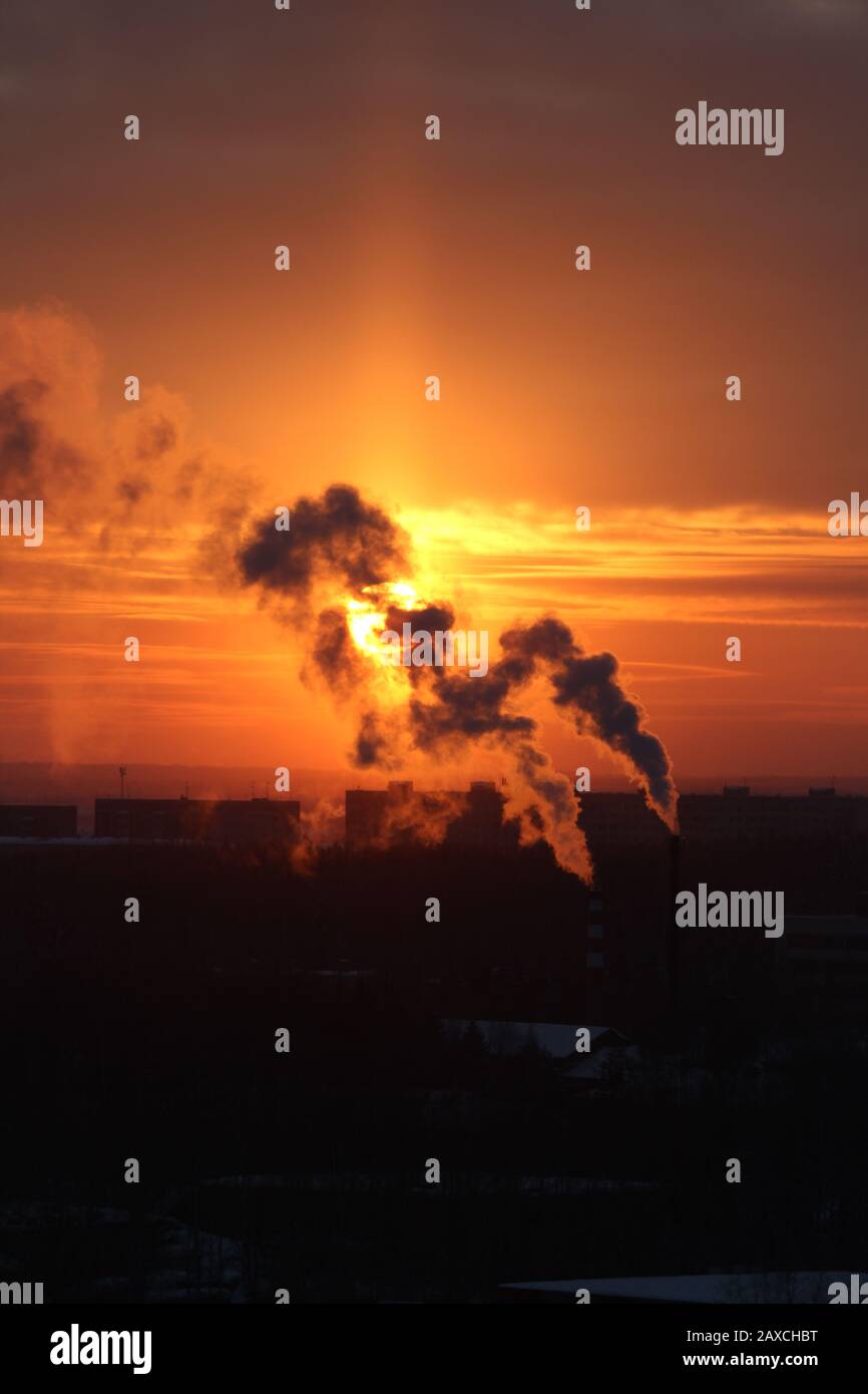 Red sun at sunset or dawn at dusk low above the horizon shrouded in ...
