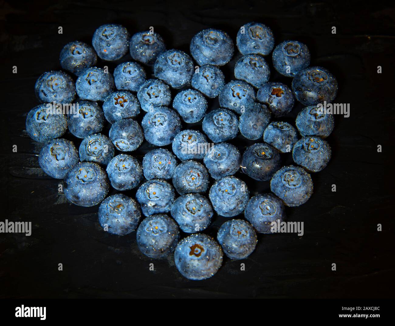 Fresh blueberries heart shape on black background. Healthy food eating ...