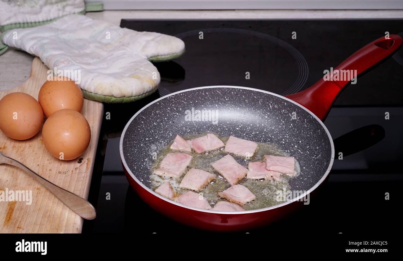frying ham in a pan before adding eggs Stock Photo - Alamy