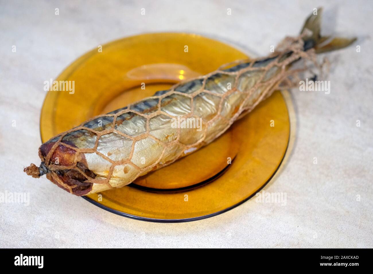 hot smoked mackerel on a glass plate. headless fish carcass in a ...