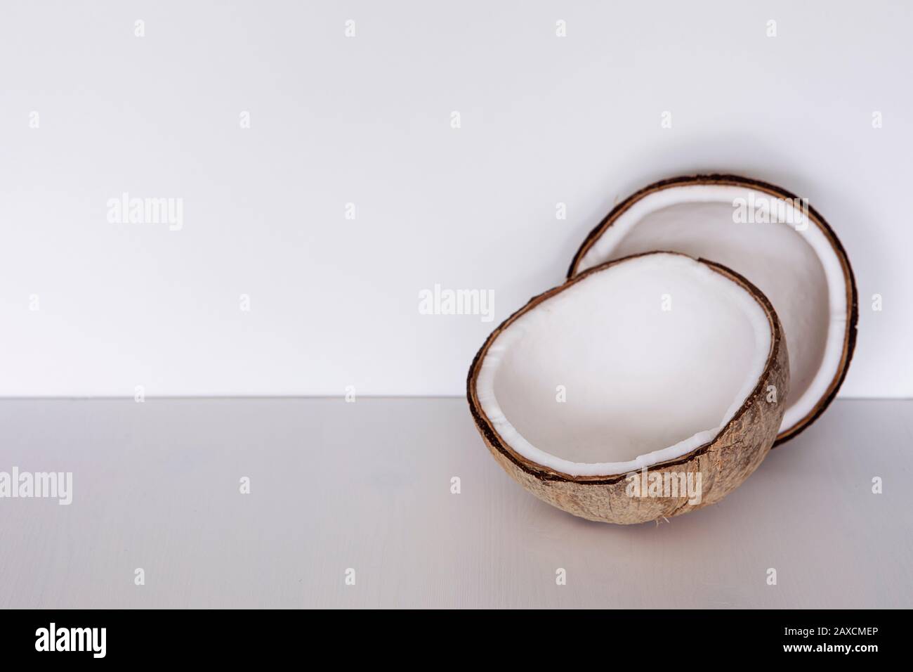 Bright coconut on white background with copy space. Two halves of ...