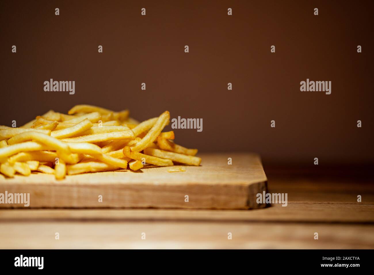 French fries on a wooden table. Food, junk food and fast food concept ...