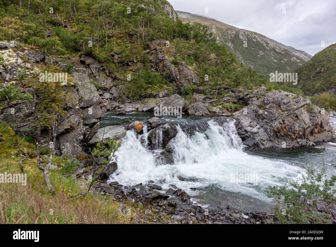 White powerful waterfall macro with water drops and beautiful mountains ...