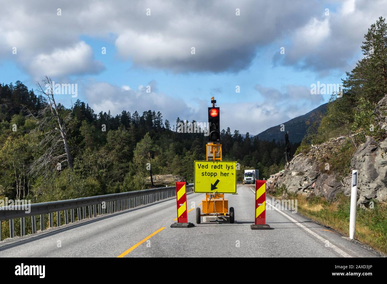 Road building traffic light signal. Mountain road stop here sign. Road ...