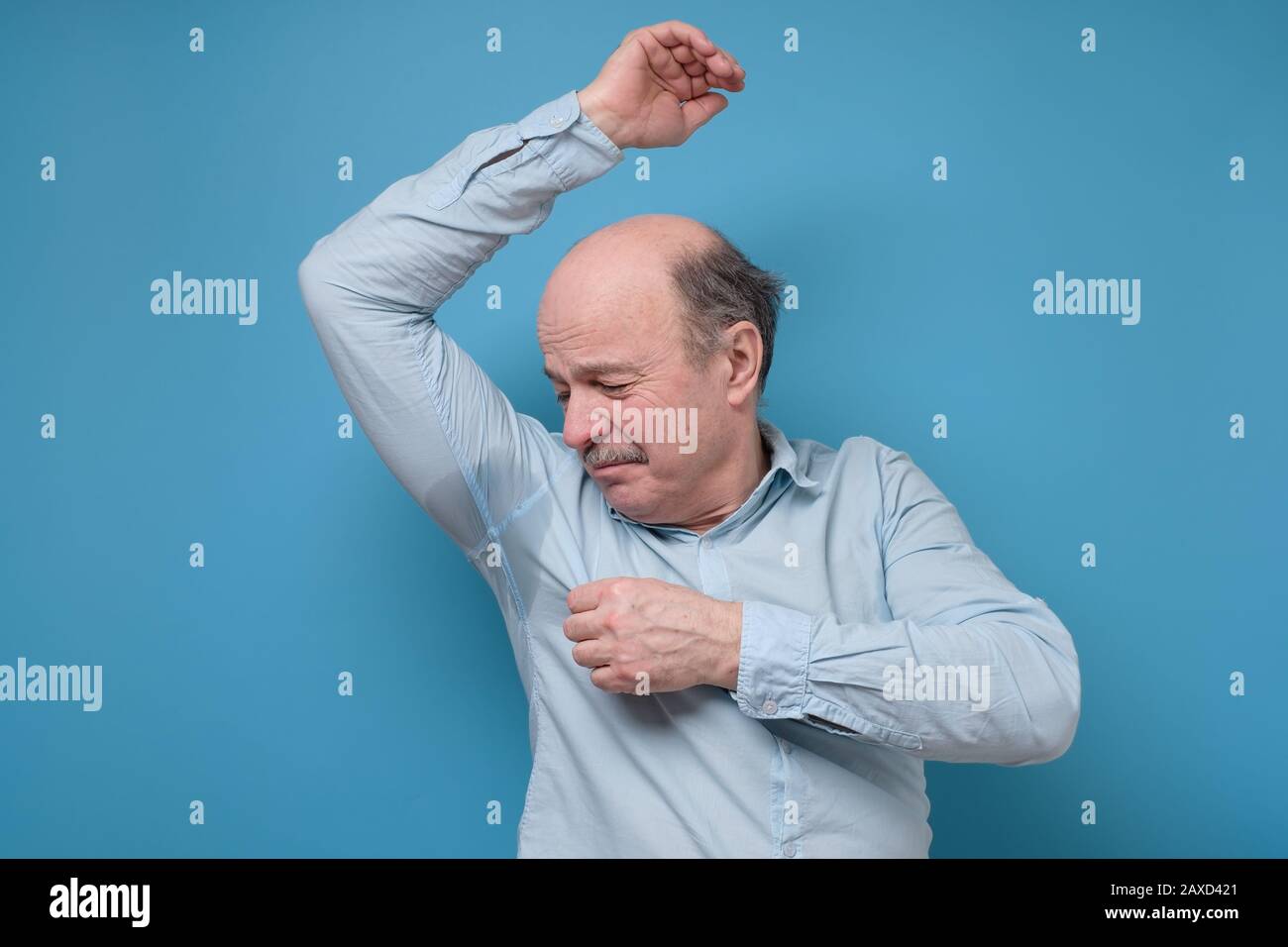 Senior hispanic man with sweat stain on his shirt suffering from hot ...