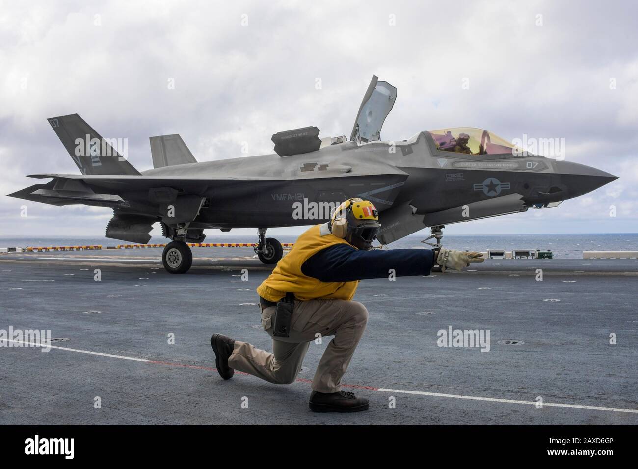 A U.S. Navy flight handler signals a Marine Corps F-35B Lightning II ...