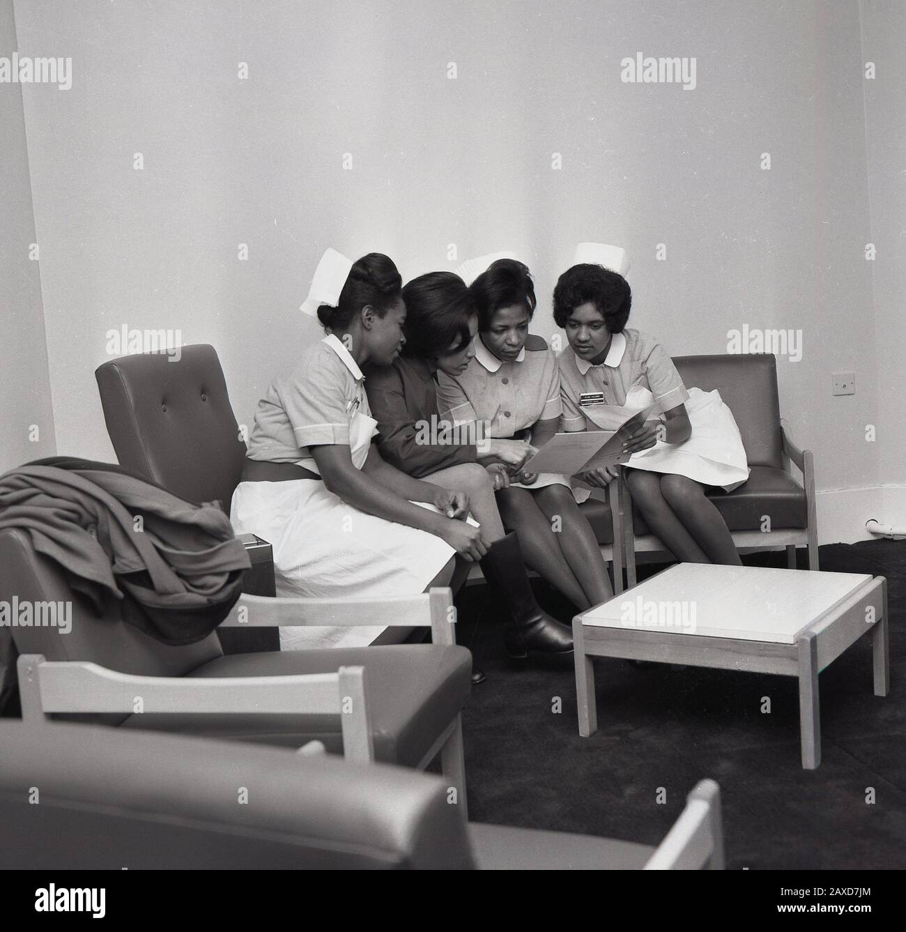 1960s, historical, four female nurses sitting together in a common room ...