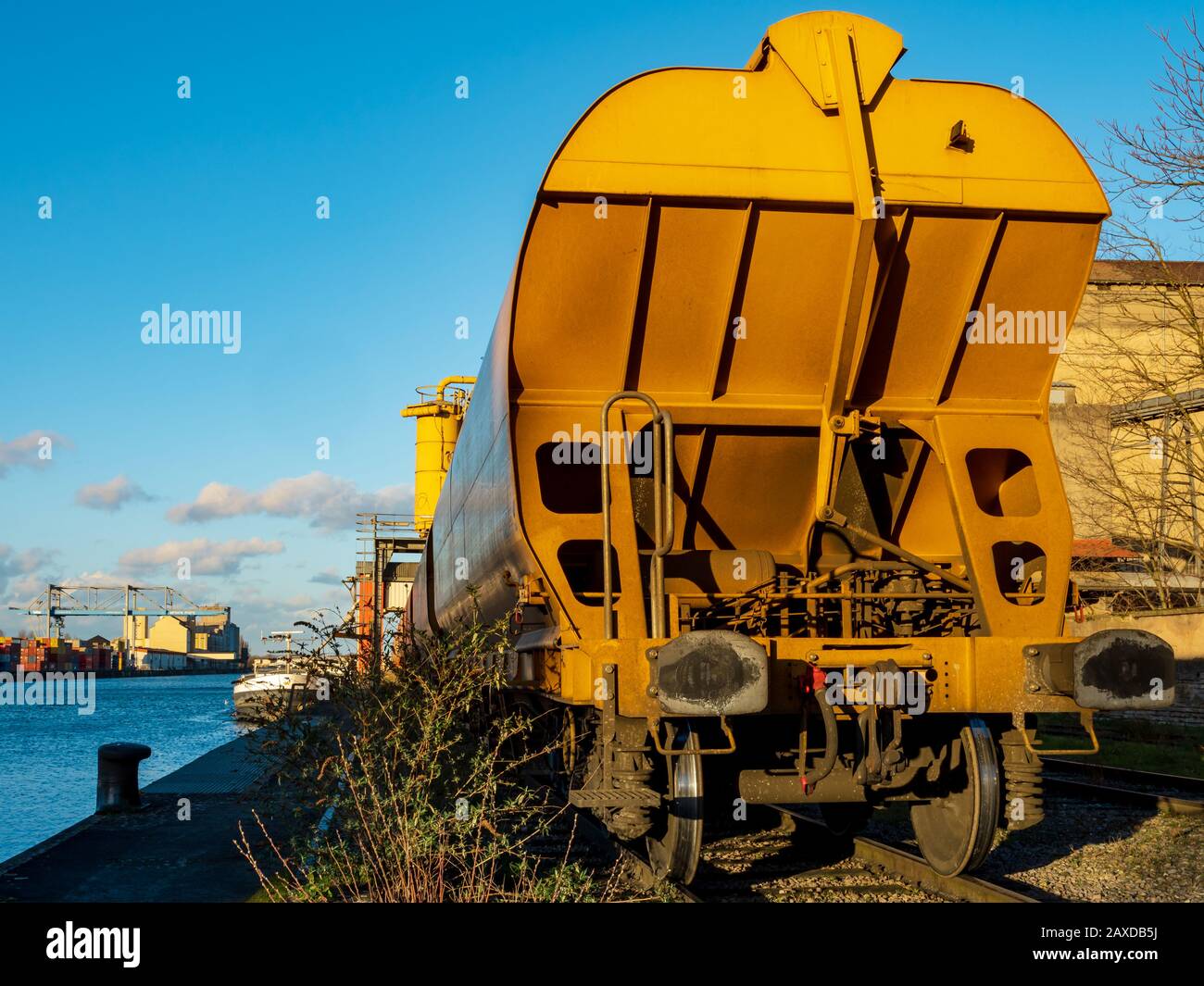 Bright yellow railway freight car against the blue sky in the port of ...