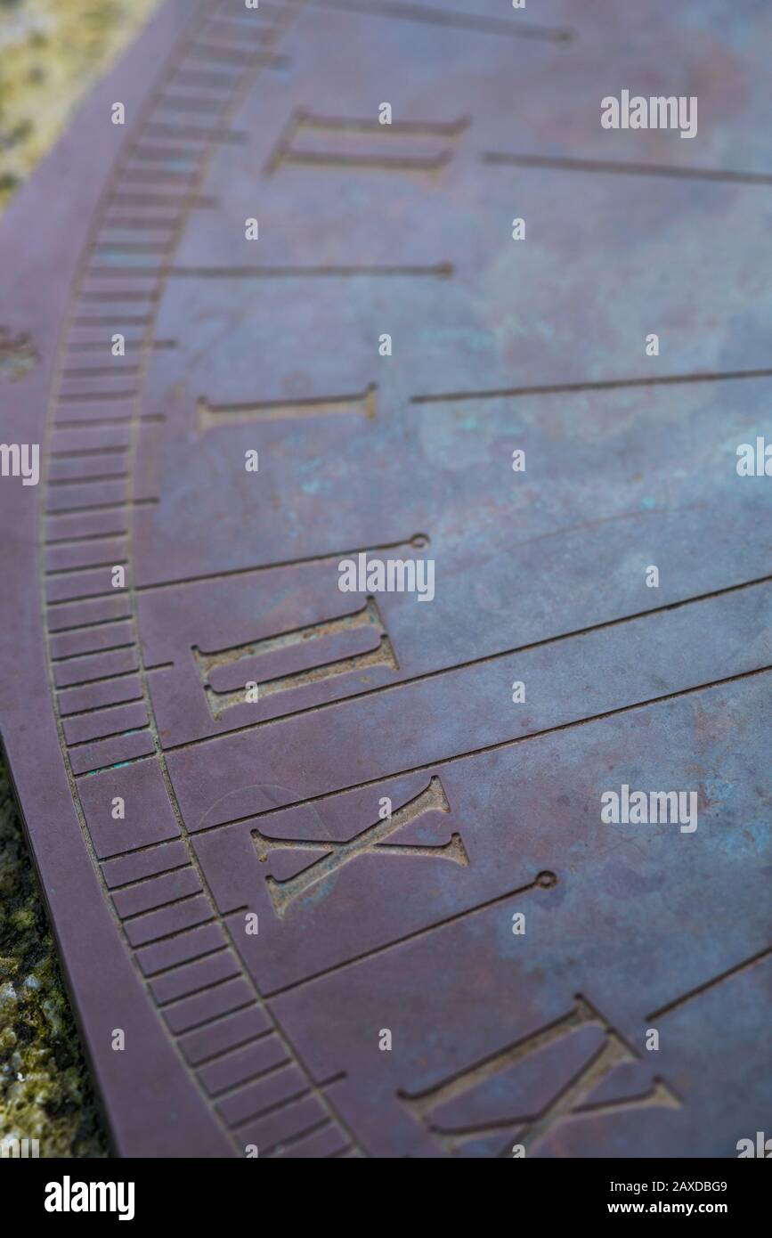 A traditional garden centrepiece, a bronze sundial on a carved stone ...